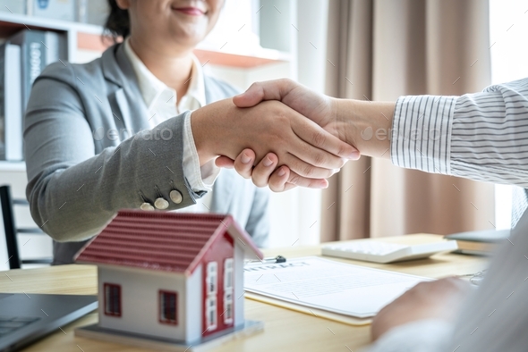 Estate agent and customers shaking hands together celebrating finished ...