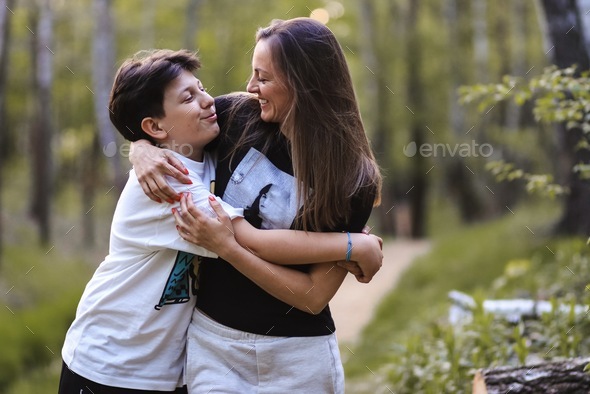 Mom and son having fun in the park in the spring time. Parents and teen ...