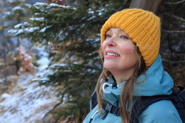 Profile of a woman while hiking in the woods.Smiling face, pop of color ...