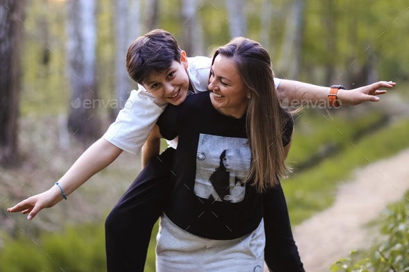 Mom and son having fun in the park in the spring time. Parents and teen ...