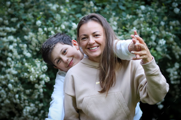 Mom and son having fun in the park in the spring time. Parents and teen ...