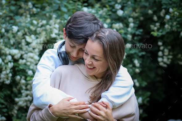 Mom and son having fun in the park in the spring time. Parents and teen ...