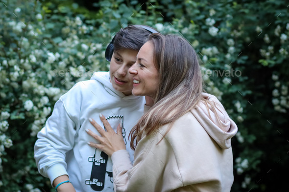 Mom and son having fun in the park in the spring time. Teenage boy and ...