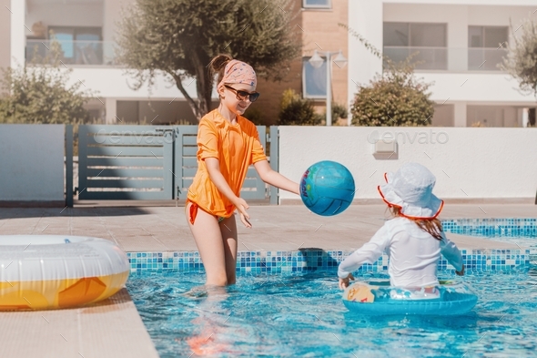 Two girls sisters having fun in pool together. Summer outdoor ...