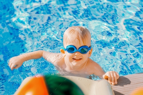 Happy cute child having fun in swimming pool. Cool family vacation in ...