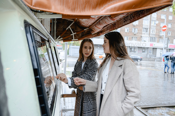 two girls buy street food Stock Photo by karmanovalive | PhotoDune