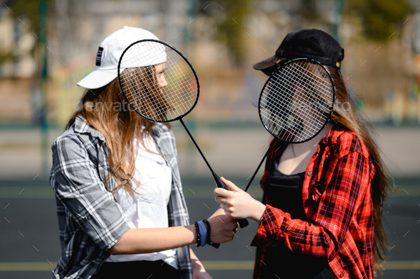 two girls covered their faces with badminton rackets Stock Photo by ...