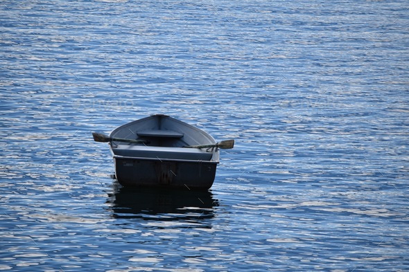 Empty rowboat in the middle of the sea Stock Photo by Malisunshine