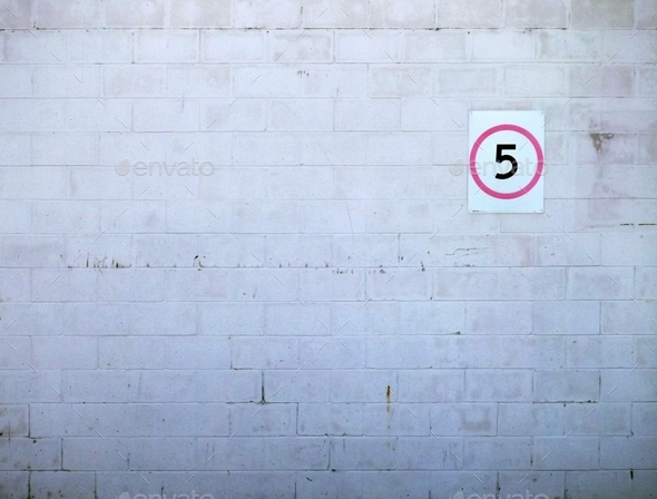 Minimalism - 5 km speed limit sign on a wall Stock Photo by iheartcreative