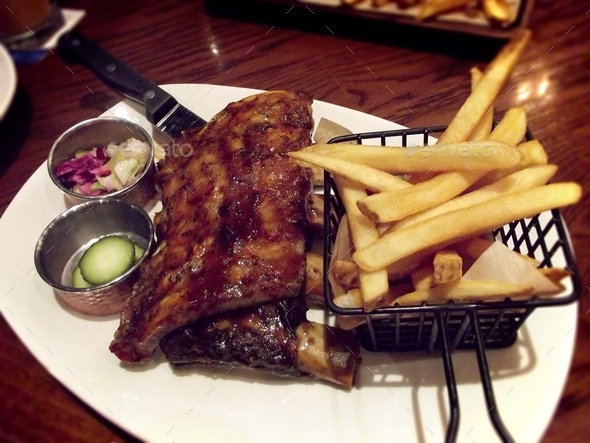 Baby back BBQ ribs with fries, pickles and coleslaw Stock Photo by ...