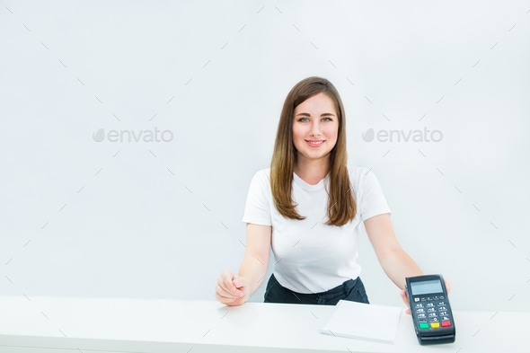 manager, seller holding payment terminal at reception desk. Contactless ...