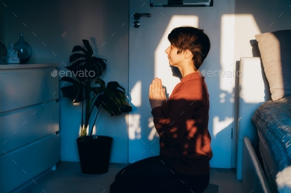 Woman doing yoga position Namaste in sunset light. Pray ritual Stock ...