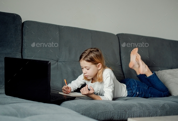 girl at home on computer doing online schooling or e-learning, early education Stock Photo by ...