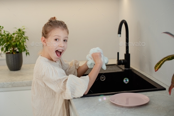 kids washing dishes at the kitchen sink Stock Photo by Yuliya_Kokosha
