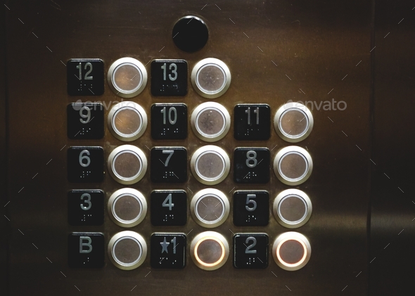 Silver circle buttons in an elevator with thirteen floors and a ...