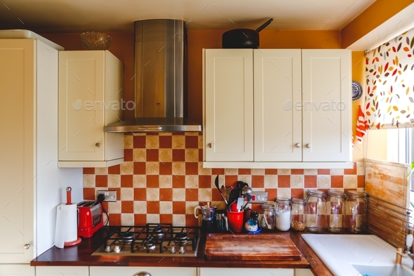 Cute cozy kitchen with checkered backsplash in an apartment with white ...