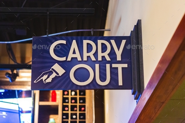 Carry Out Sign pointing finger sign at a restaurant in front of bar and ...