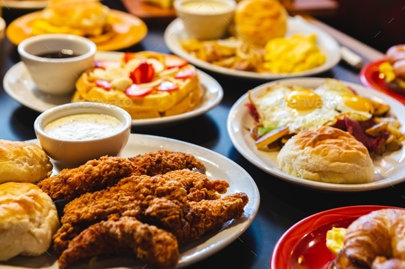Table full of delicious spread of breakfast foods, diner food, chicken ...