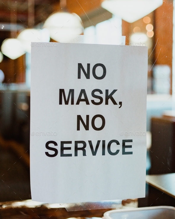 No mask, no service sign on a glass barrier in a restaurant during ...