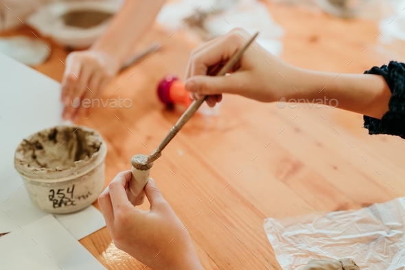 Close up photo of child hands working with clay at ceramic workshop ...