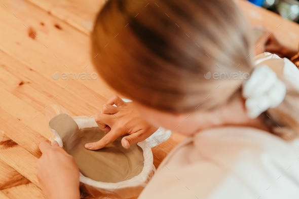 Close up photo of child hands working with clay at ceramic workshop ...