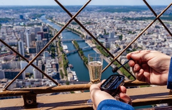 Having glass of champagne with black caviar on the top of Eiffel Tower ...