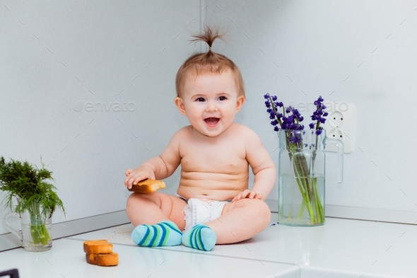 Cute little baby with cookies sitting on the table in the kitchen Stock ...