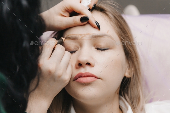 master browist marking on the eyebrows for applying paint. microblading ...