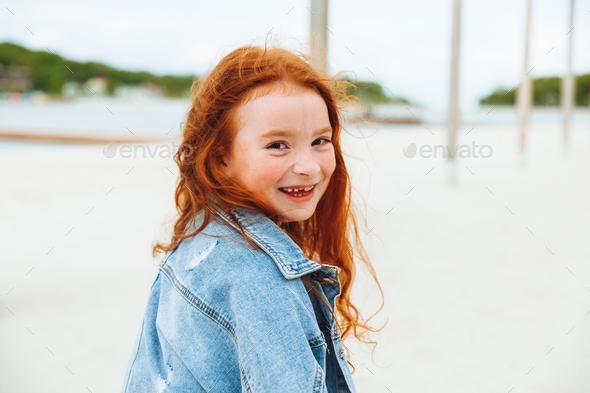 portrait of a girl with long red hair. child on the beach.summer ...
