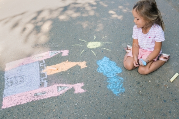 Children chalk drawing a castle outside Stock Photo by TGordievskaya