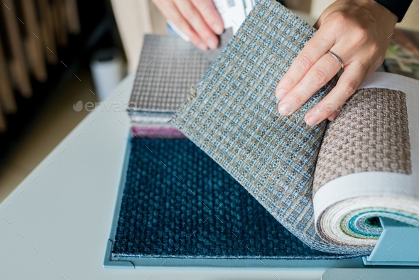woman choosing fabrics swatches for sofa in store. Interior designer ...