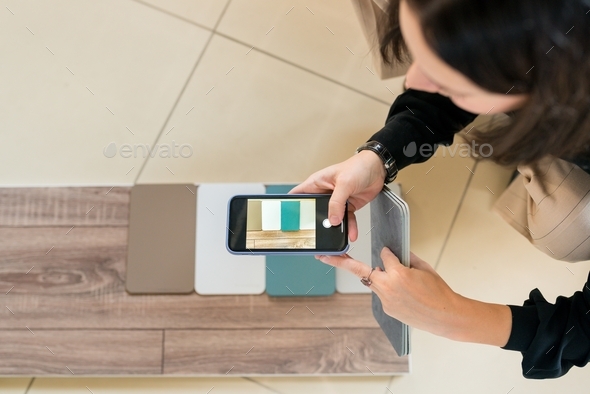 Woman designer photographing samples of materials for a new home on a ...