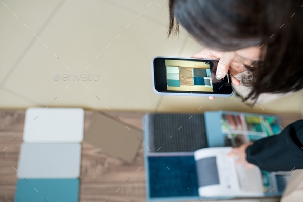 Woman designer photographing samples of materials for a new home on a ...