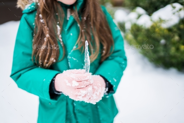 Outdoor winter activities for kids. Close up of child girl hands ...