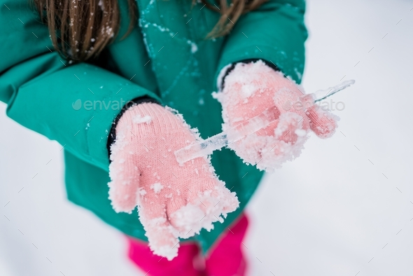 Outdoor winter activities for kids. Close up of child girl hands ...