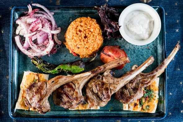 Spicy lamb chops with bulgur and onion on the dish in restaurant in ...