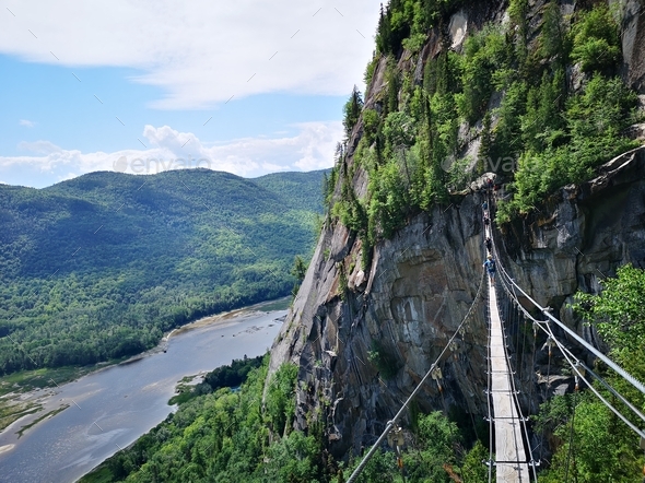 Hanging rope bridge suspended between two mountain peaks and offers ...
