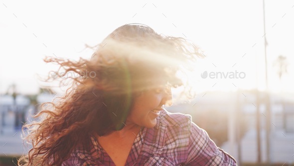 Happiness - happy woman with curly and windy hair blowing in the ...