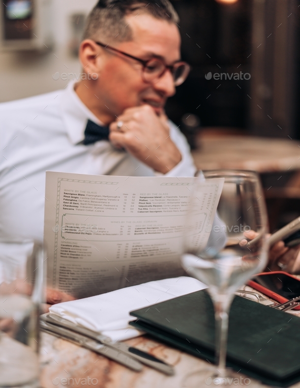 Man wearing glasses and holding menu at fine dining restaurant Stock ...