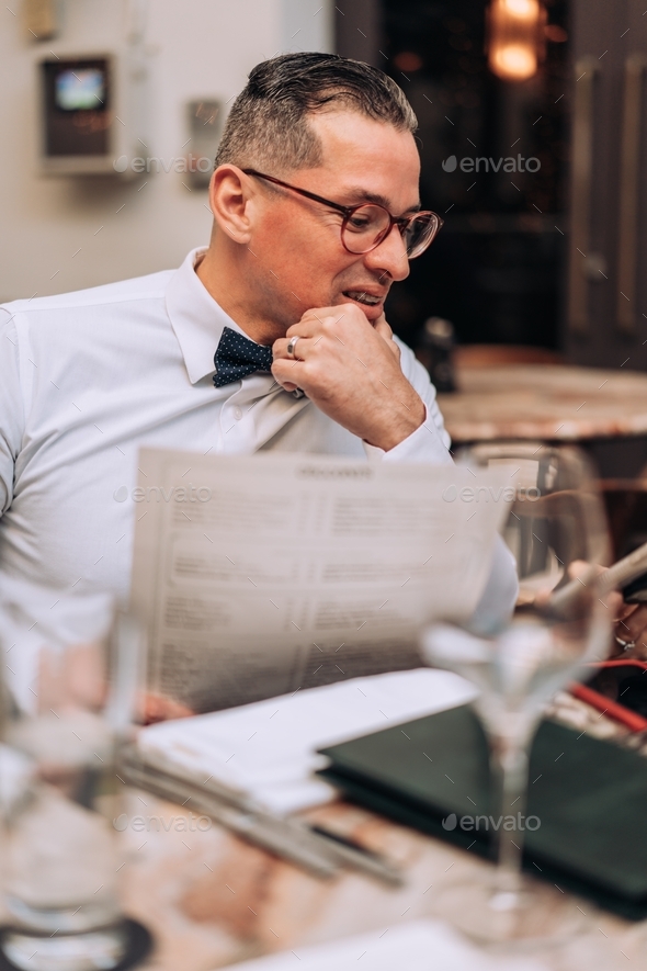 Man looking at menu in restaurant Stock Photo by Elisall | PhotoDune