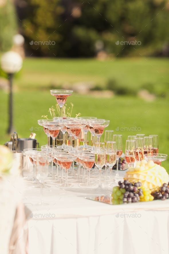 Welcome bar. A pyramid of champagne glasses and snacks on the table at ...