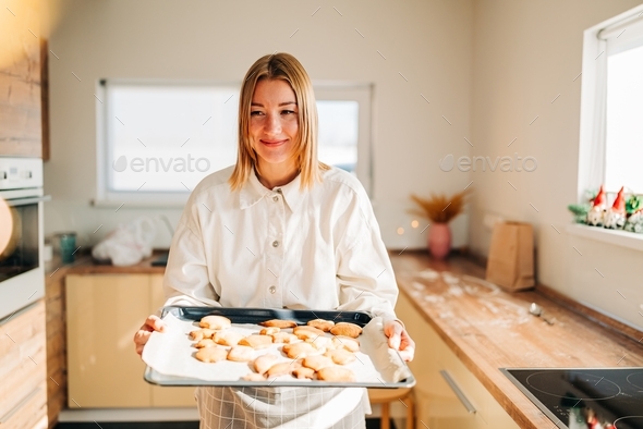 Woman smiling cooked cookies and bringing them to the kids on the ...