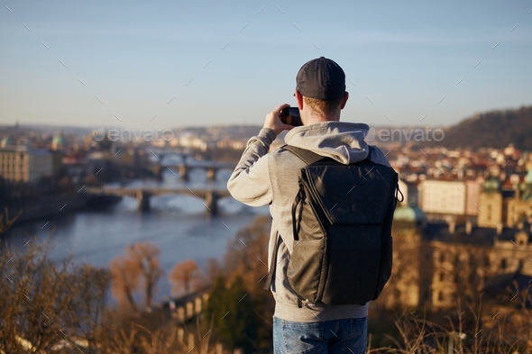 Man photographing urban skyline. Rear view of traveler against ...