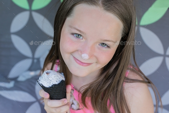Portrait of a cute little girl eating oreo ice cream. Summer lifestyle ...