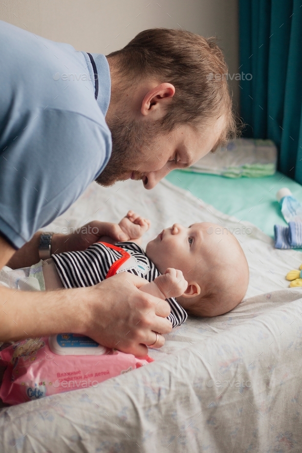 young dad changing baby's diaper Stock Photo by loskyt7 | PhotoDune