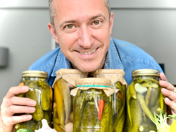Portrait of man is doing pickles jars stock for winter season. Organic ...