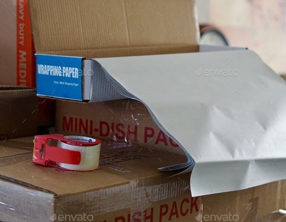 Moving boxes, wrapping paper, and a roll of packing tape Stock Photo by ...