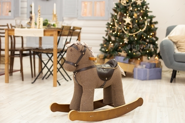 Textile brown soft rocking horse stands on the floor, home interior ...