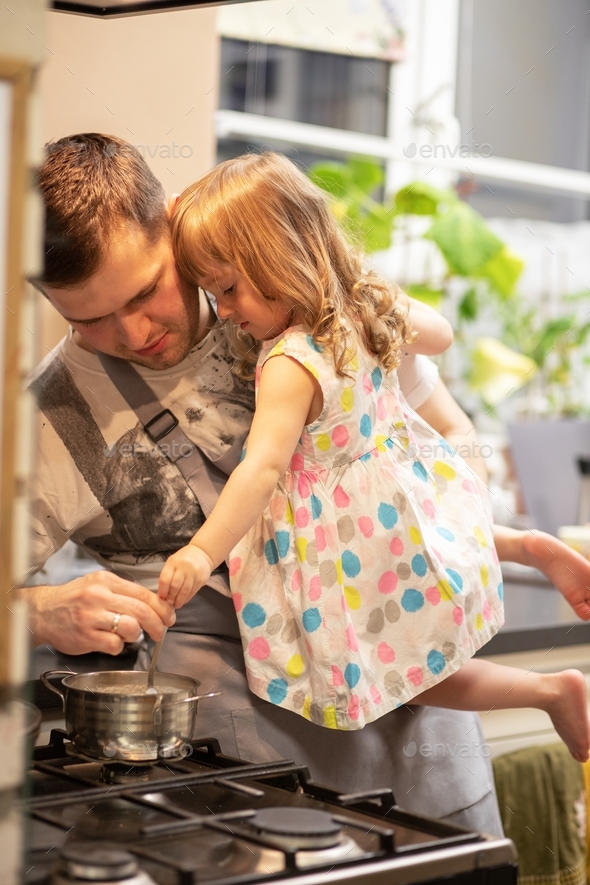 Father and daughter doing household chores in the kitchen. father and ...