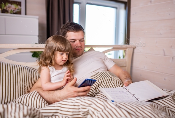 Father daughter time. Dad reading book, notebook. Stock Photo by ...